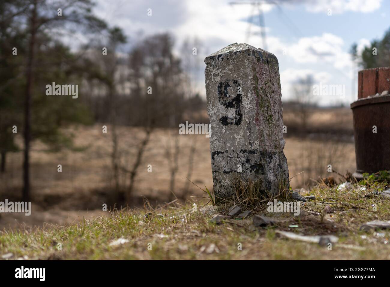 Concrete pole with black number 9 on a pole. On a spring day, there is ...