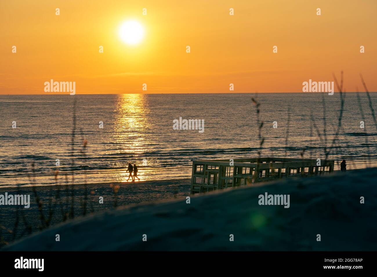 sunset landscape on the sea shore with the sun setting in the sea and ...