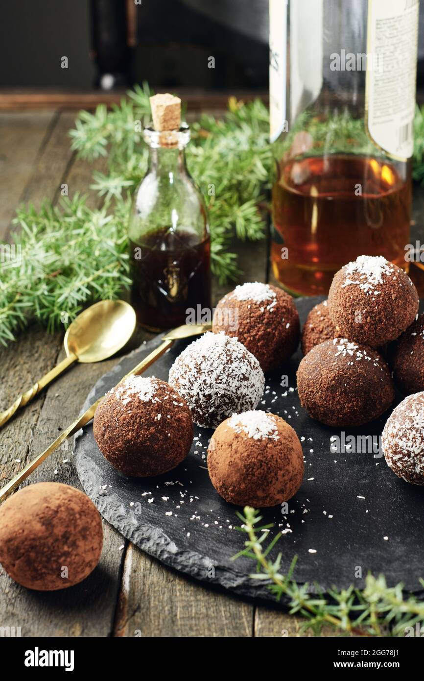 Chocolate rum balls with coconut flakes, sweet candies on a dark ...