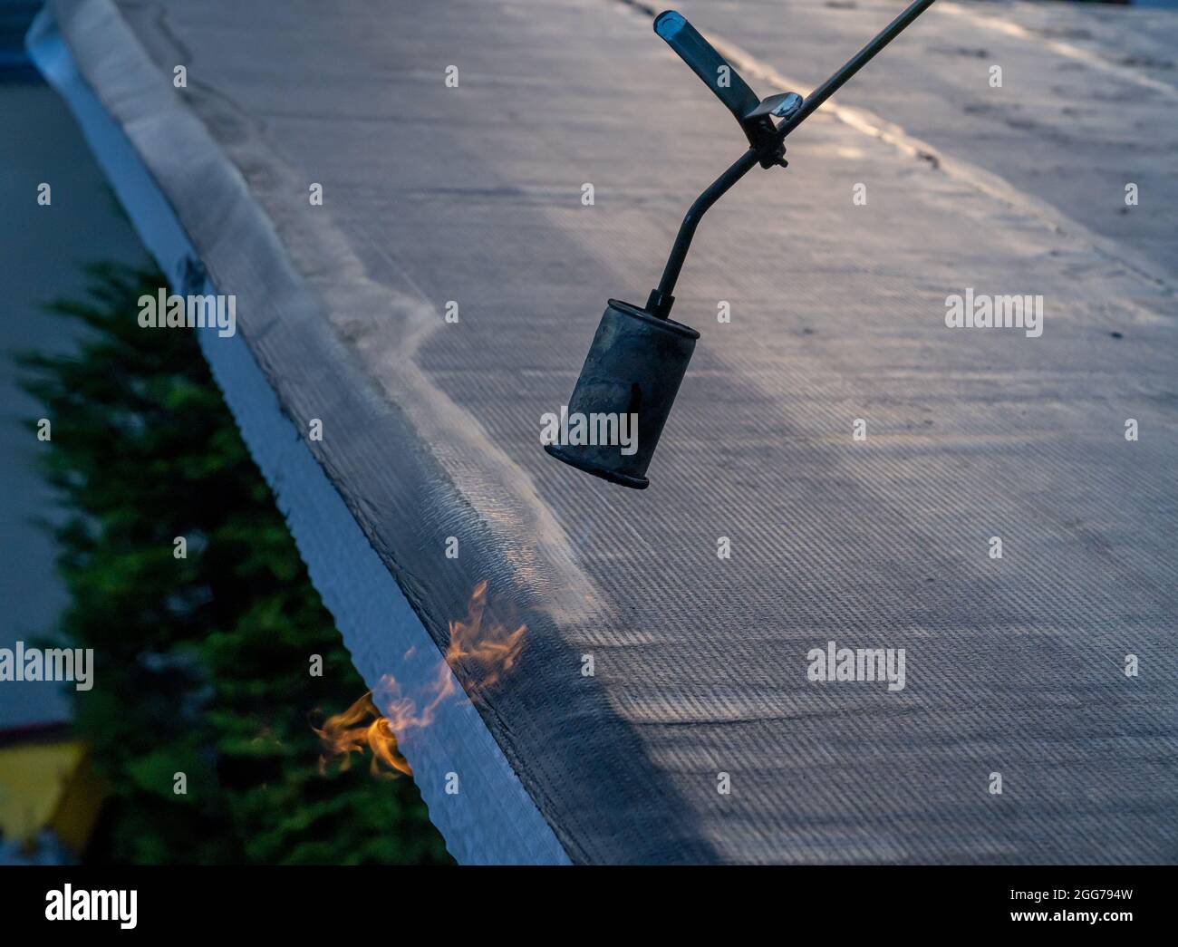 by heating the edge of the roof bitumen waterproofing with a gas burner ...