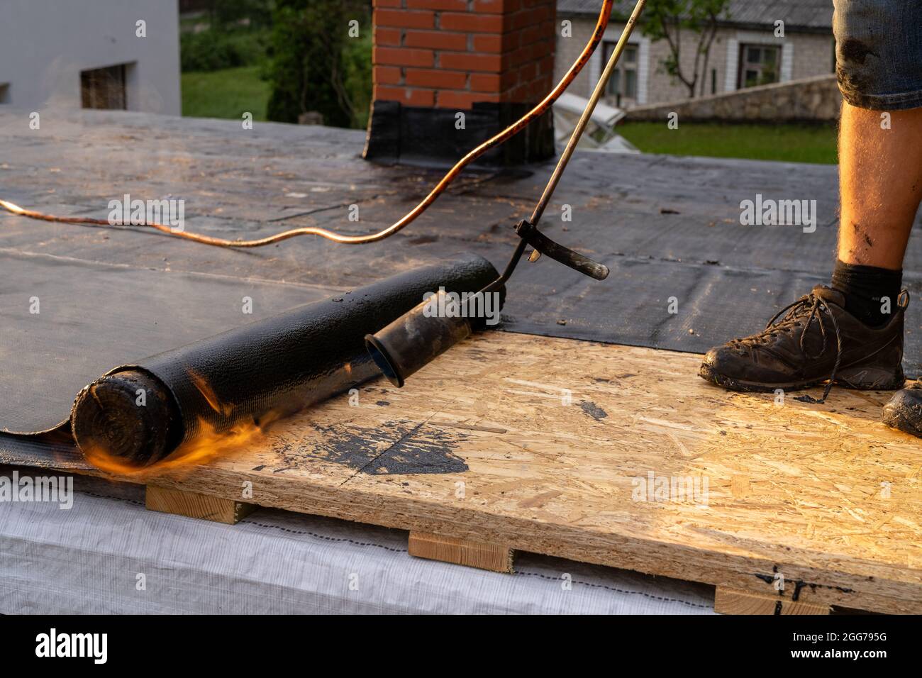 on a flat roof, the bitumen roof insulation is melted with a gas burner ...