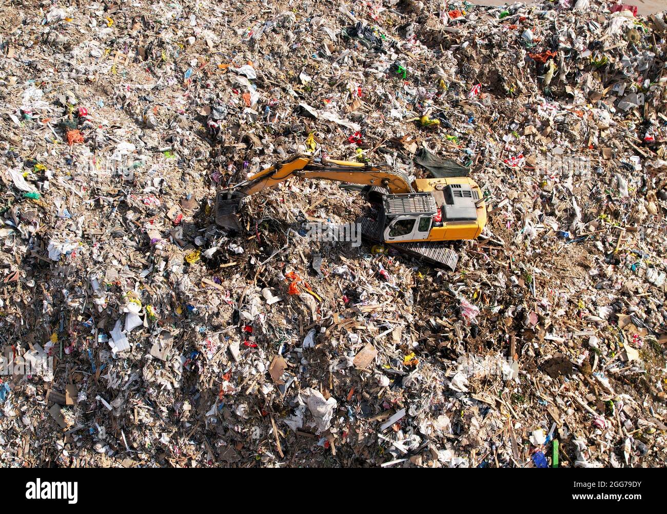 Garbage dump with construction waste. Excavator during recycling of ...