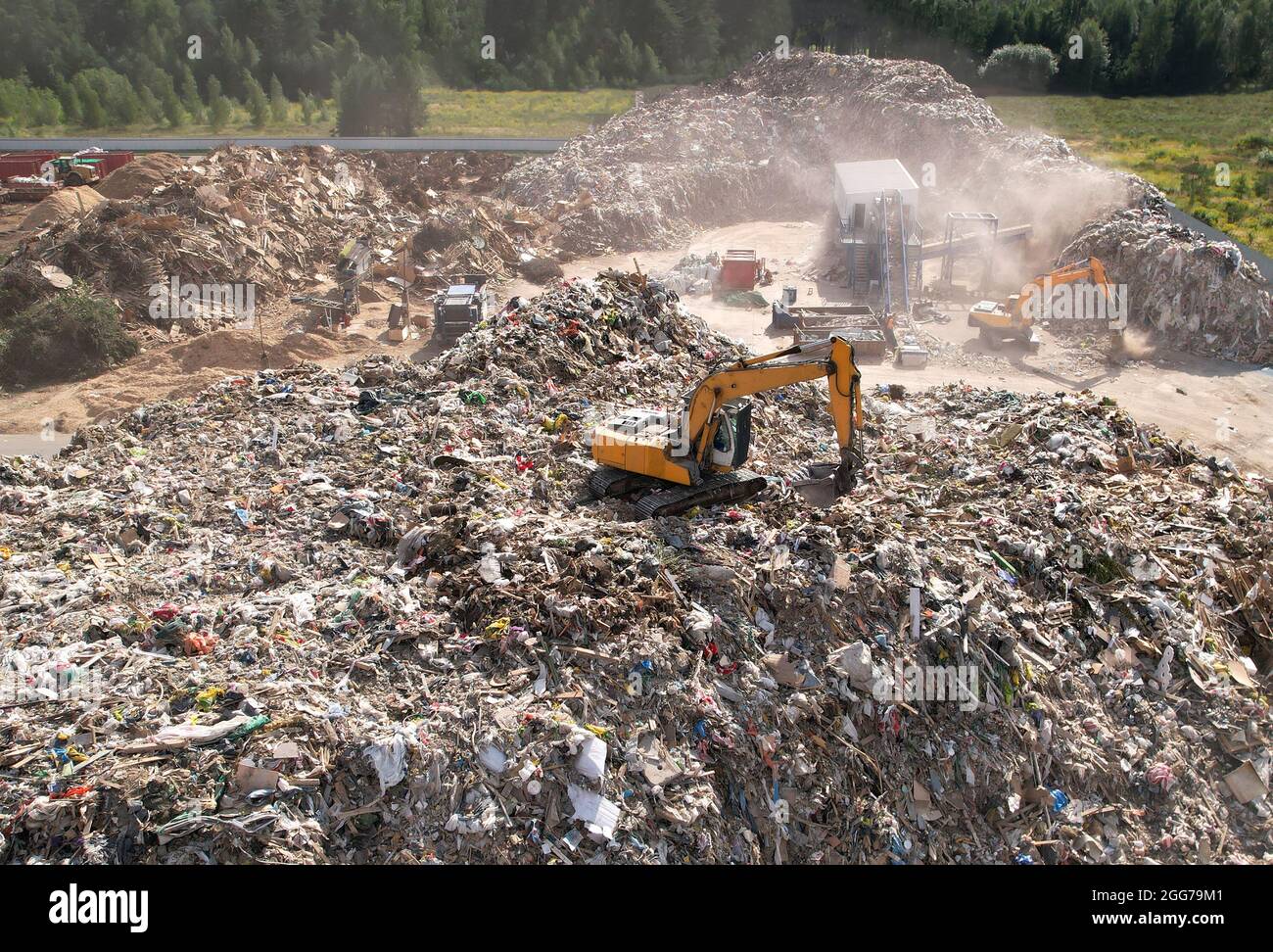 Garbage dump with construction waste. Excavator during recycling of ...