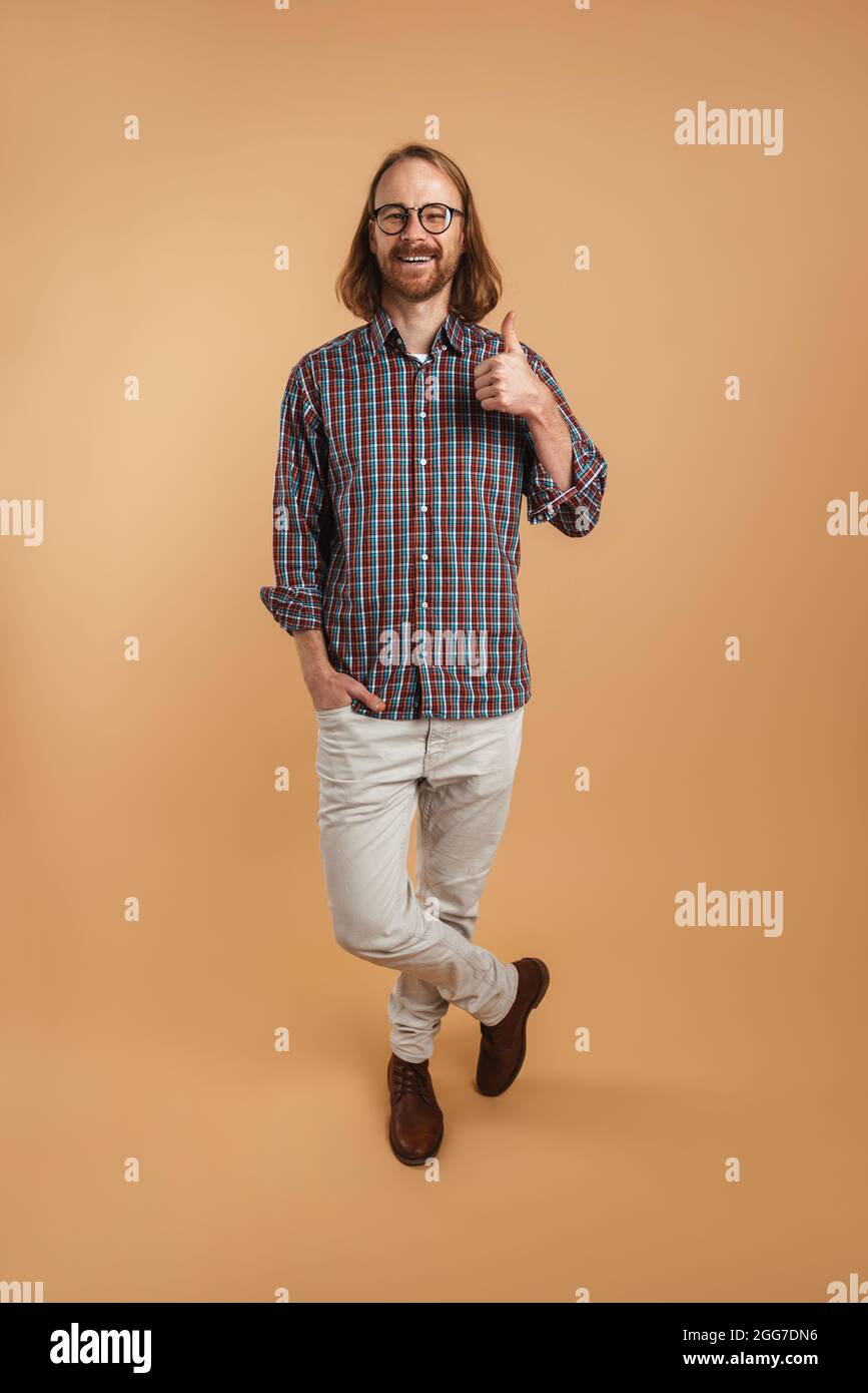 Bearded ginger man wearing eyeglasses smiling and showing thumb up ...