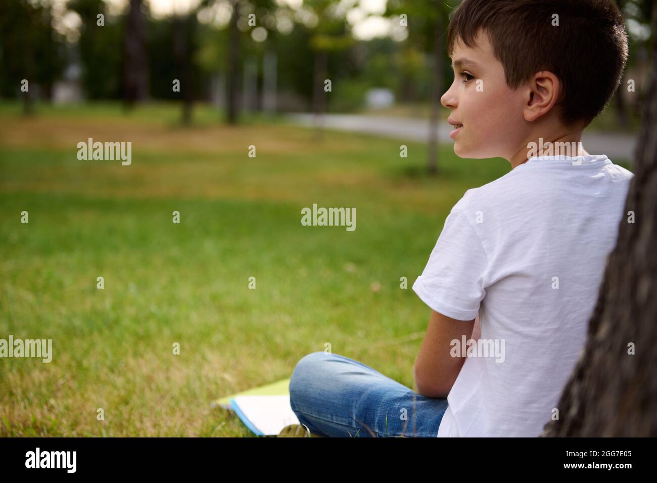 Close-up side face portrait of happy and distracted school boy looking ...
