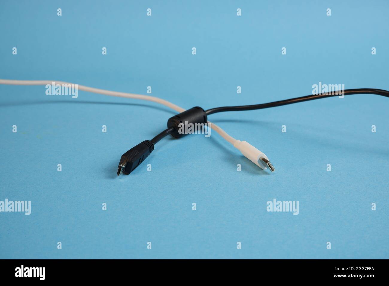 White and black wires with different usb interfaces on a blue ...