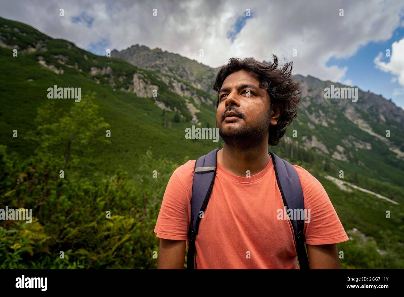 Portrait of an adventurer Indian tourist man looking up towards the way ...