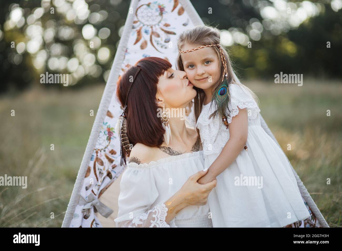 Family shot in native american indin style. Happy young mother cuddles ...