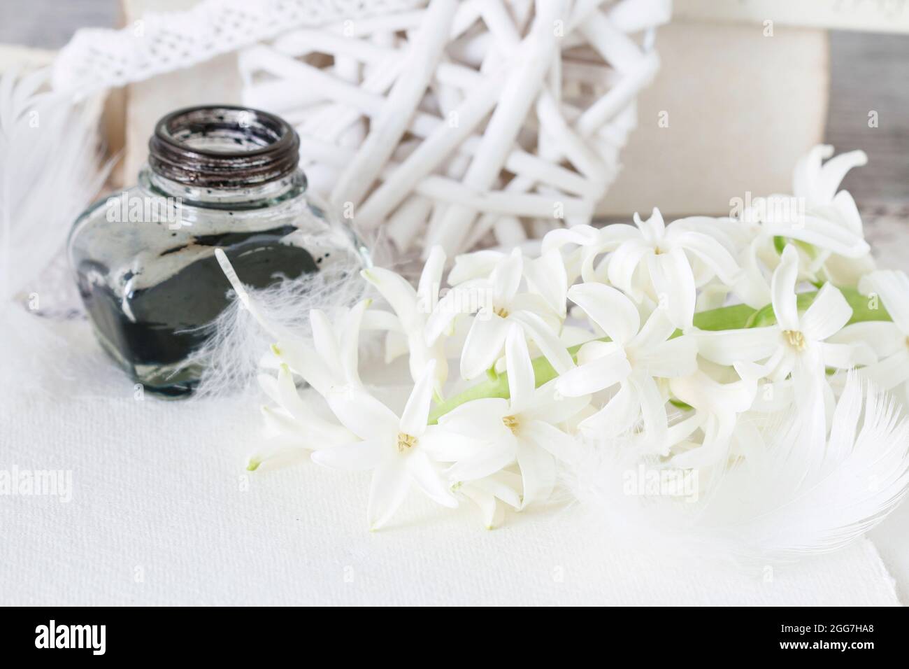 Hyacinth flower, inkwell, white feathers and sheet of paper. Retro ...