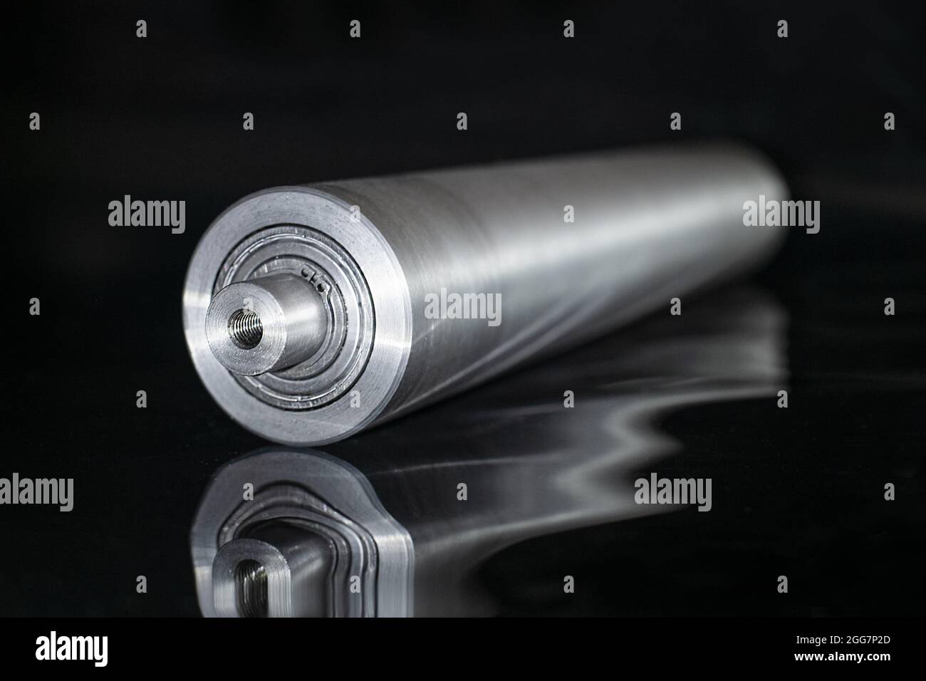 Steel metal pipe-shaft made on a lathe for the factory conveyor ...