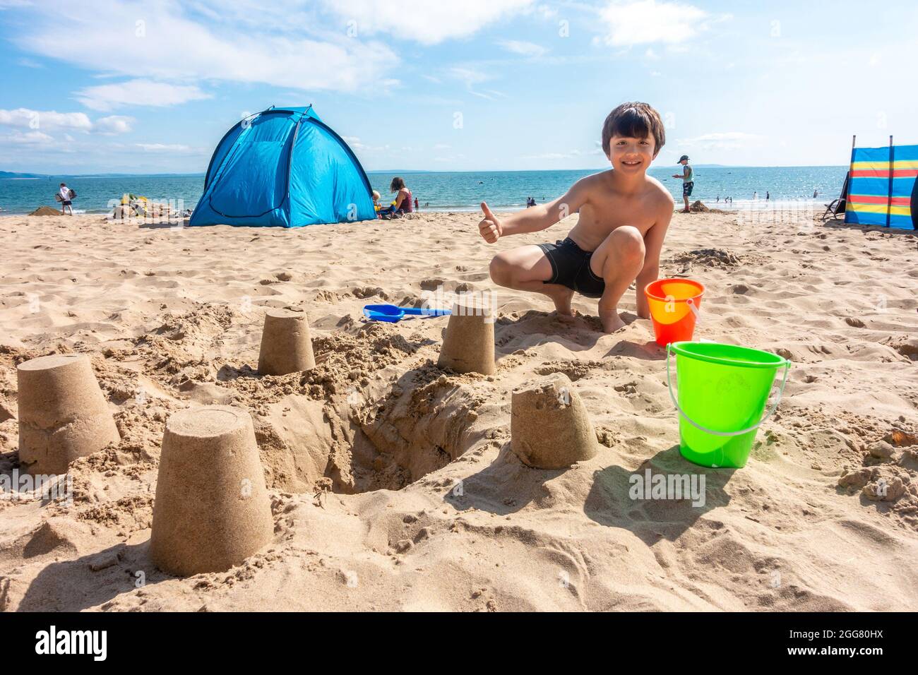 Boy playing with bucket and spade in the sand hi-res stock photography ...