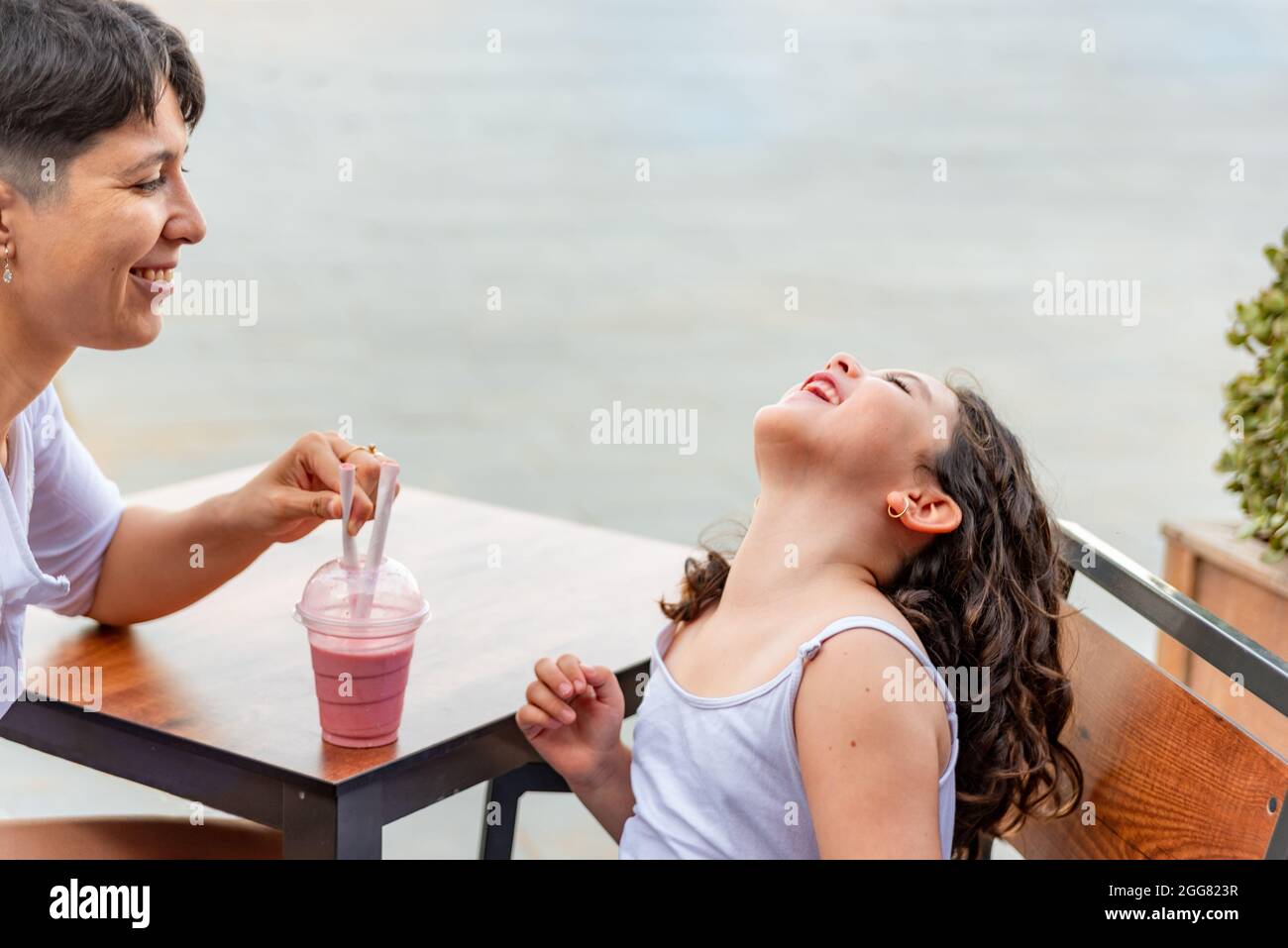 Mother and daughter having fun drinking milkshake Stock Photo - Alamy