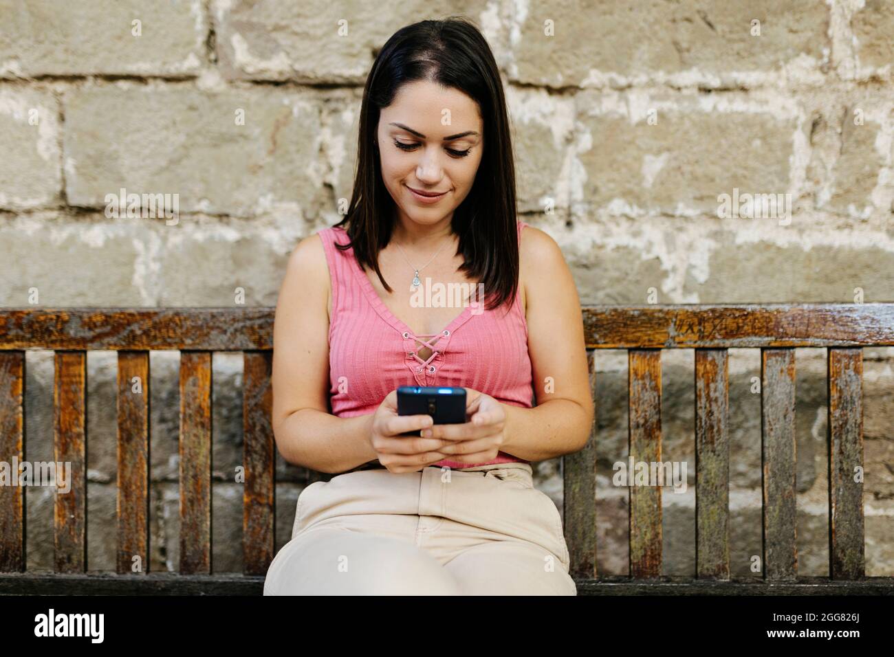 Young woman phone sitting on bench at park hi-res stock photography and ...