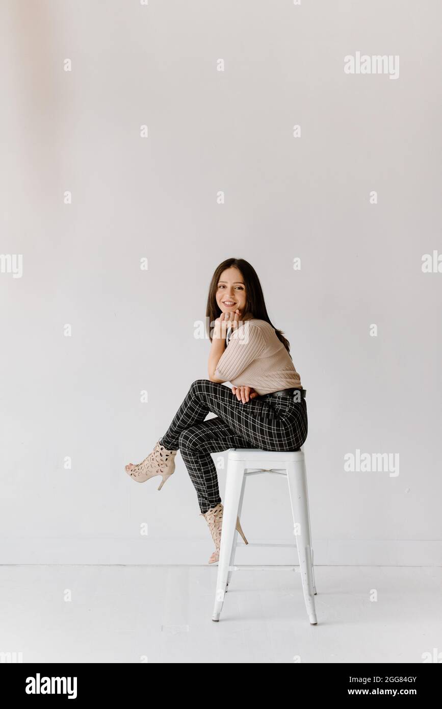 Woman sitting on stool legs crossed hi-res stock photography and images ...