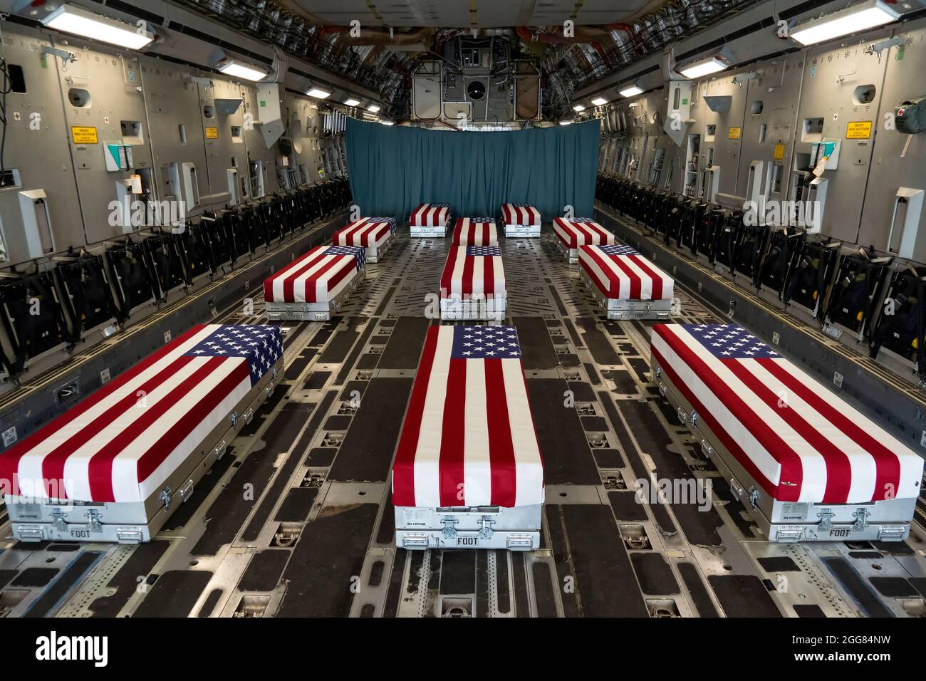 Flag-draped transfer cases line the inside of a C-17 Globemaster II Aug ...