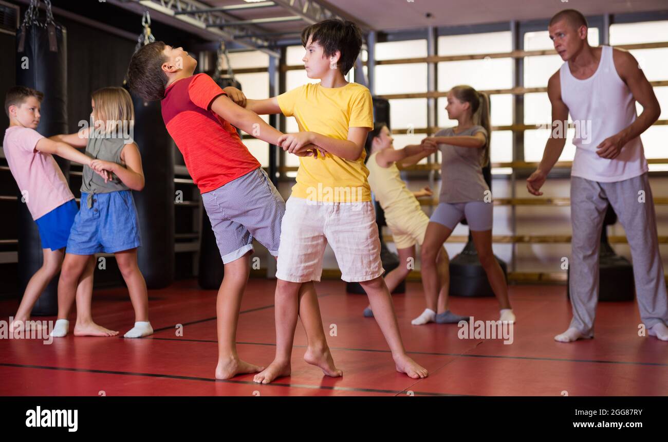 Kids in pair exercising self-defense movements Stock Photo - Alamy
