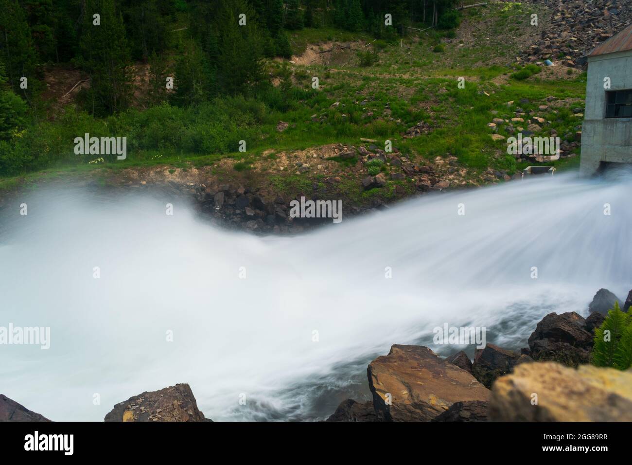 Water coming out of dam control building at mountain lake, United ...