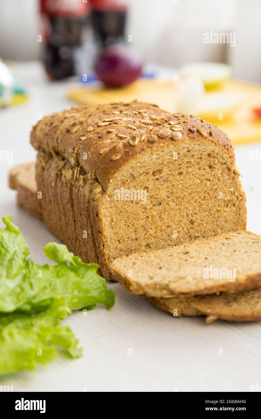detail of a sliced wholemeal bread mold next to a lettuce, food ...