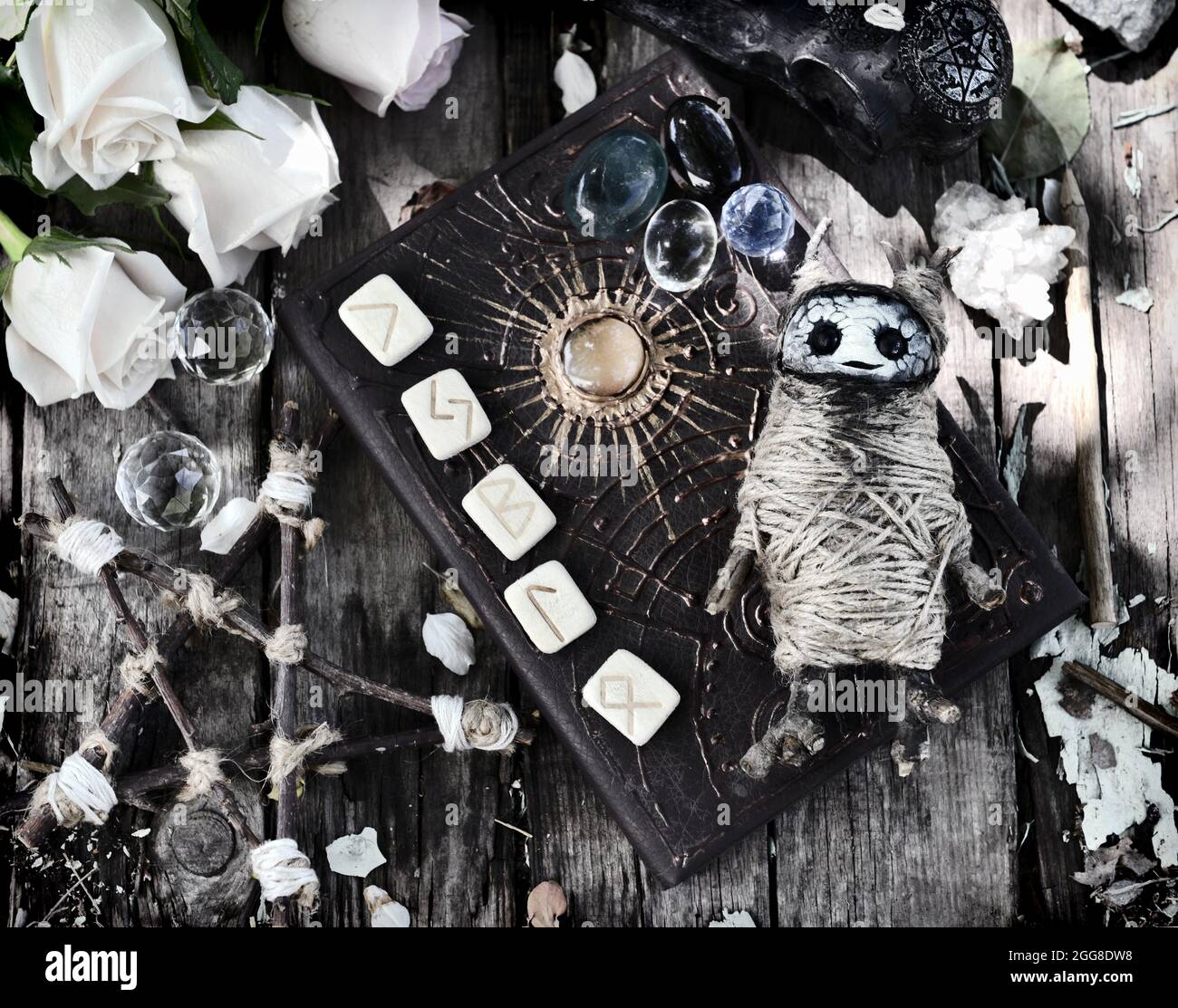 Grunge still life with voodoo doll, decorated witch book, runes and ...