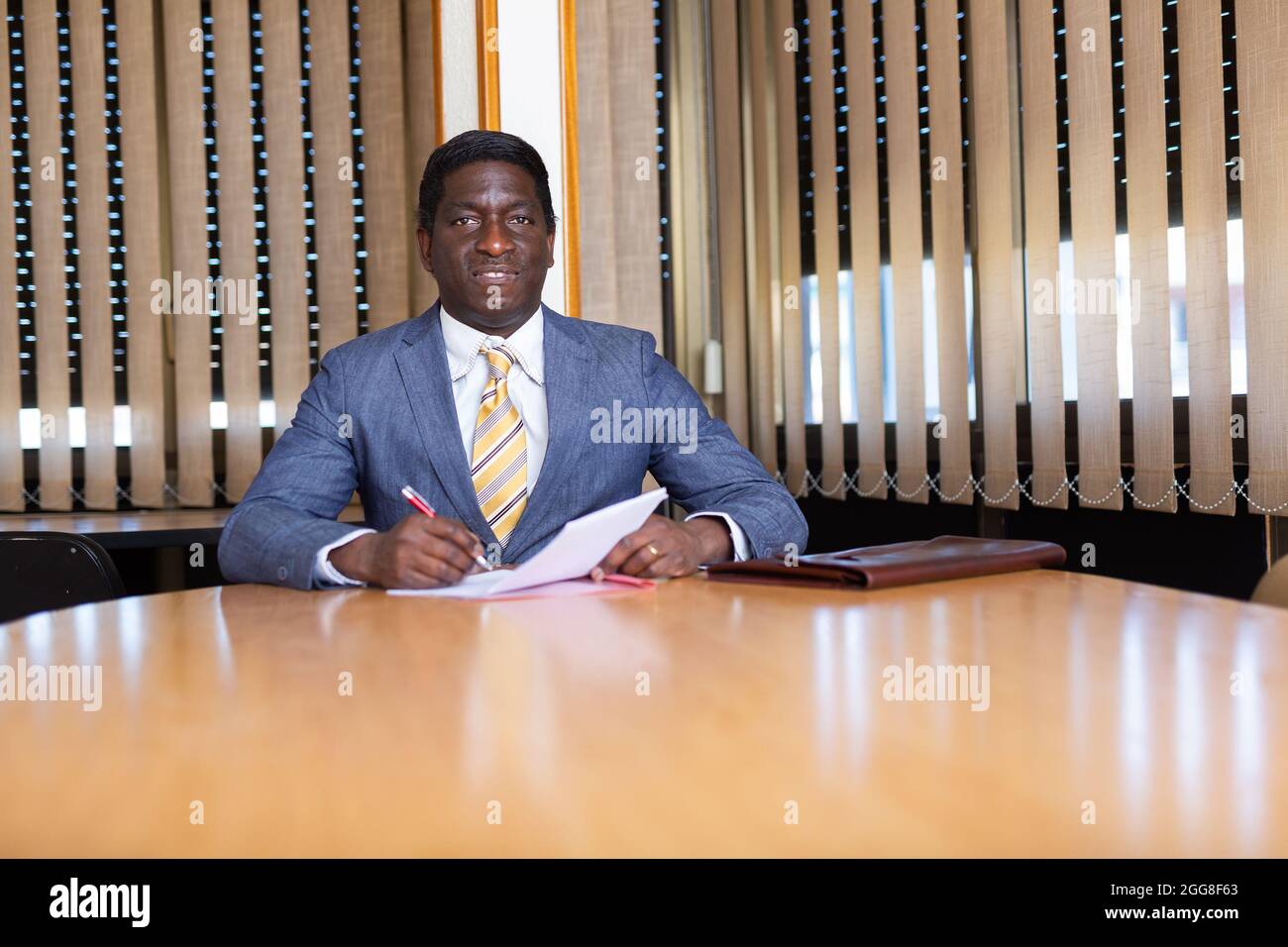 African american businessman signs documents while sitting at the ...