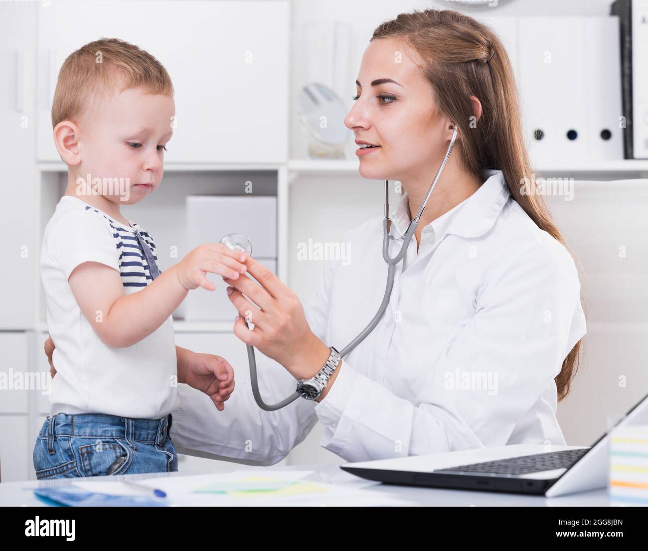 Paediatrist woman is listening kid with a stethoscope Stock Photo - Alamy