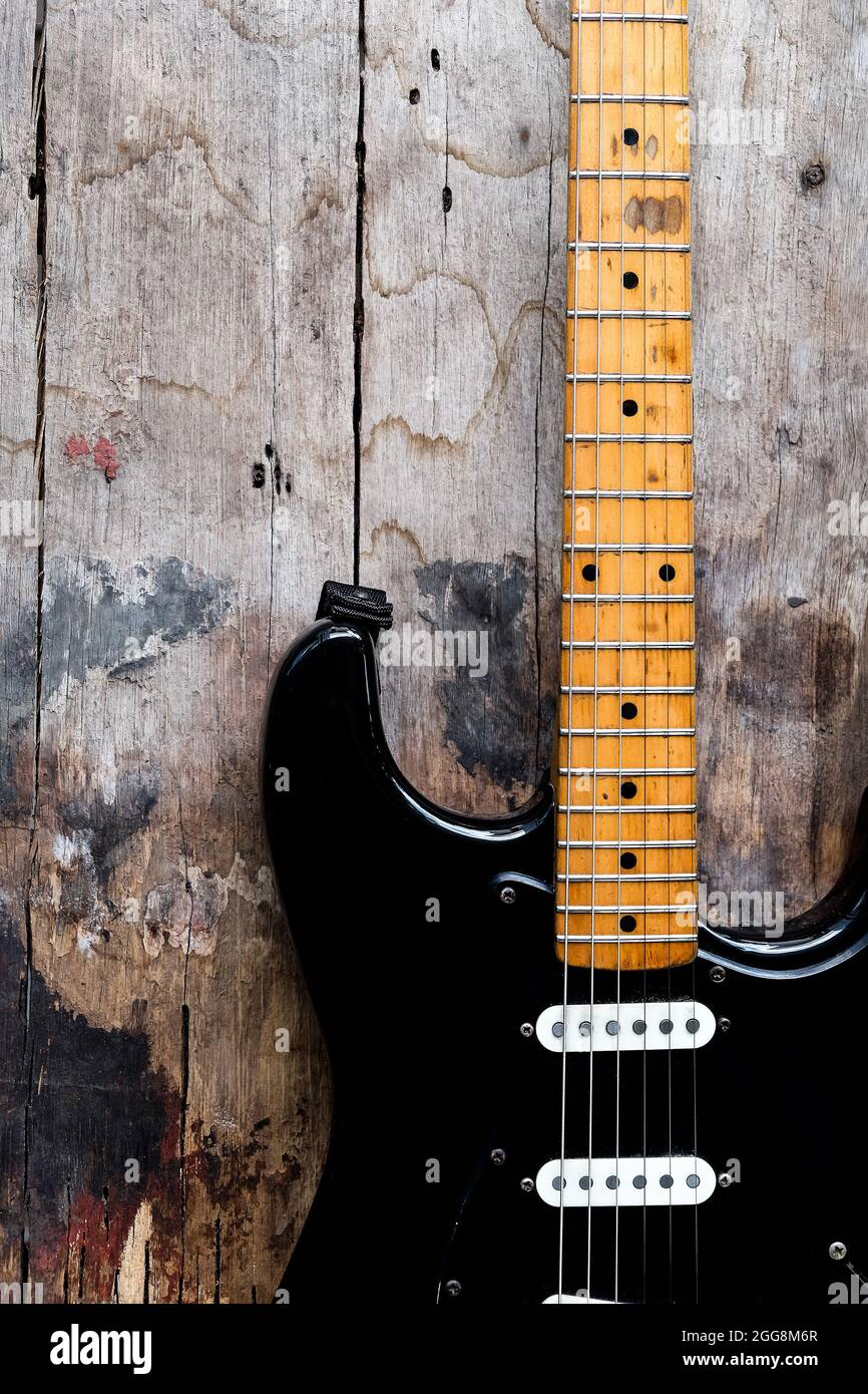 Detail of Black Electric Guitar on a wood background Stock Photo - Alamy