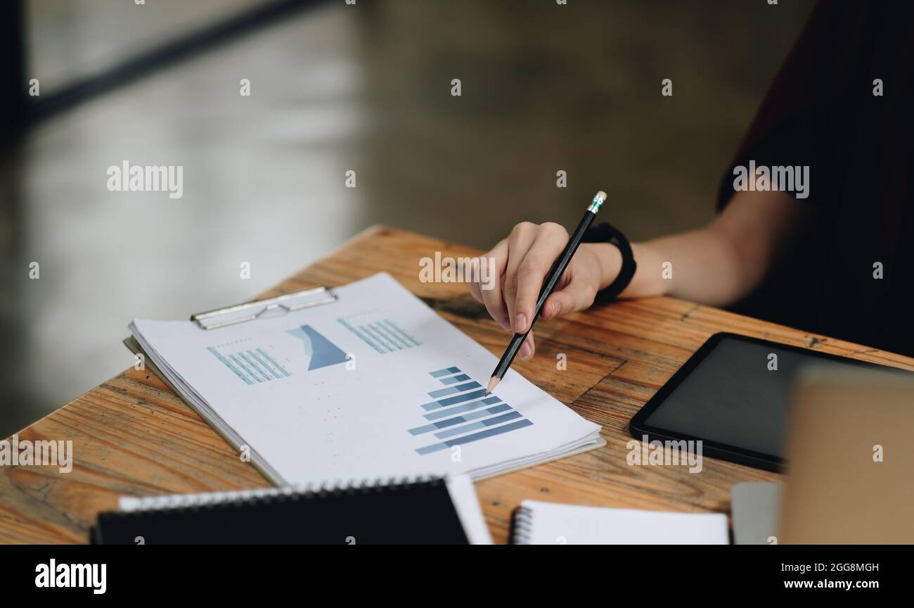 Close up business woman holding pen and pointing paper chart summary ...