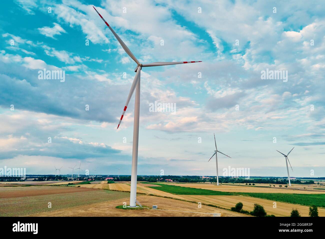 Windmill among agricultural fields. Wind turbine generator at summer ...