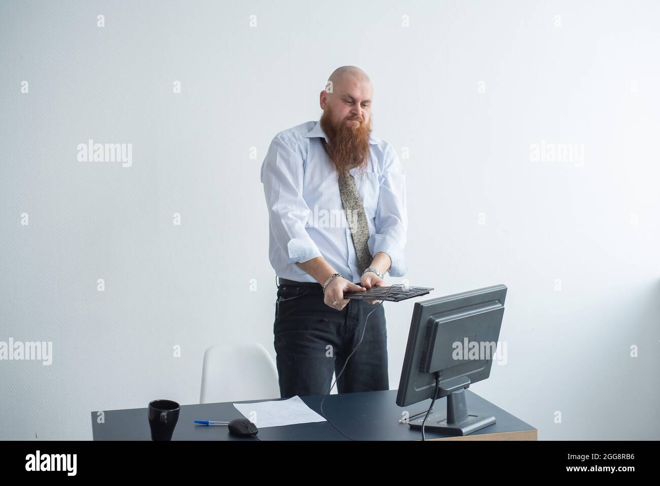 Angry bald man with a red beard in the office in a business suit ...