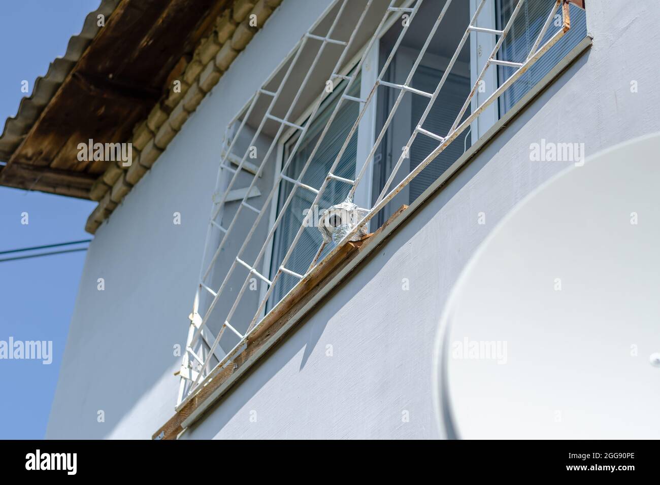 CCTV camera is installed on the metal lattice of the window. The video ...