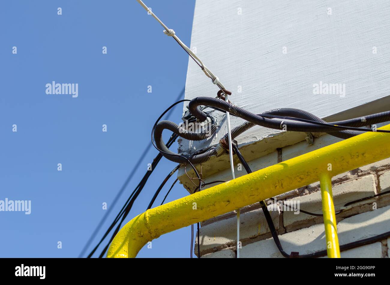 Yellow gas line and various electrical wires on the outside corner of ...