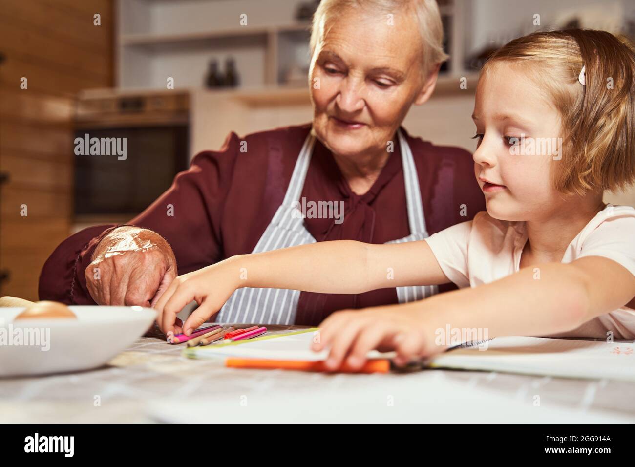 Kid picking a pink coloured pencil for drawing Stock Photo - Alamy