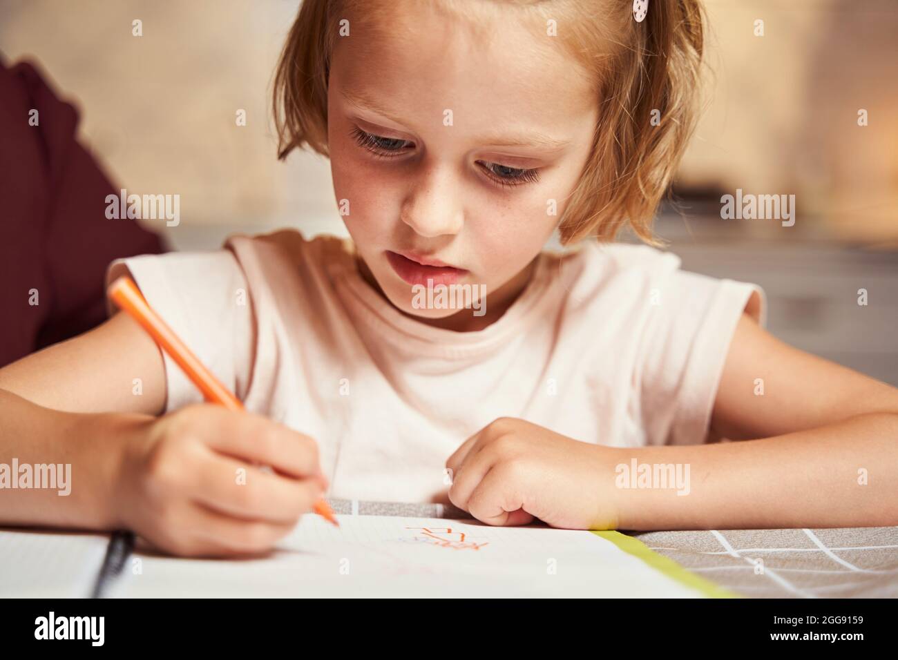 Concentrated kid using orange marker for painting picture Stock Photo ...