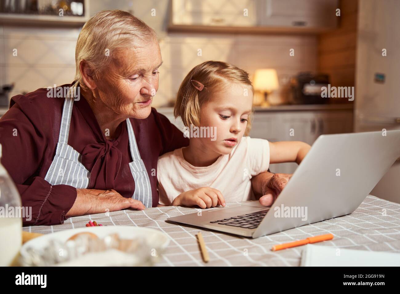 Curious granddaughter learning to use computer with granny Stock Photo ...