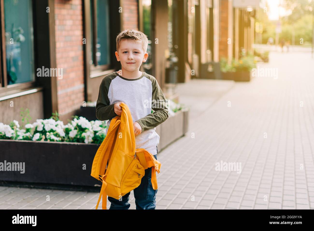 Back to school. Cute child packing backpack, holding notepad and ...