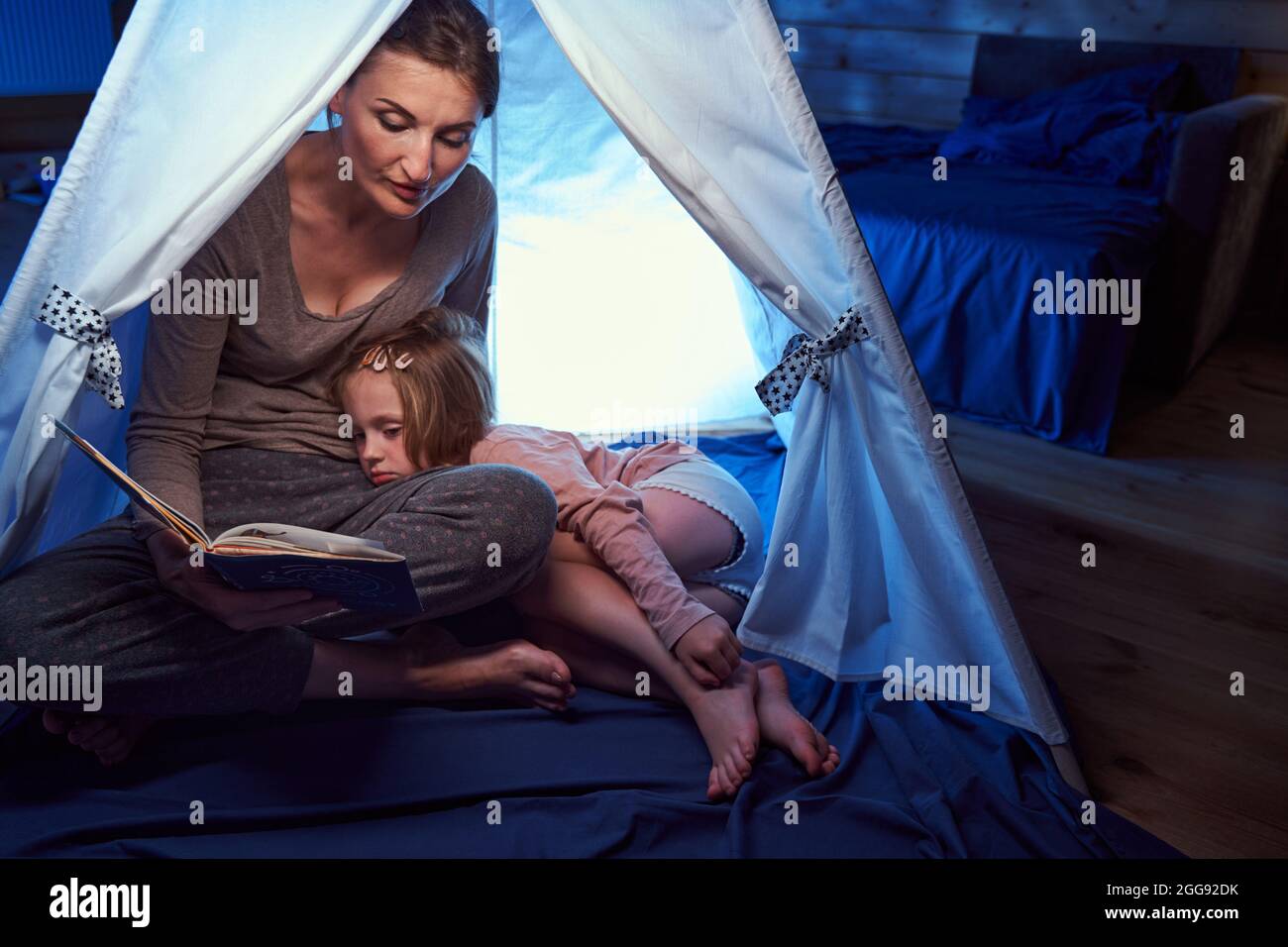 Kid going to sleep while her mother reading bedtime stories Stock Photo ...