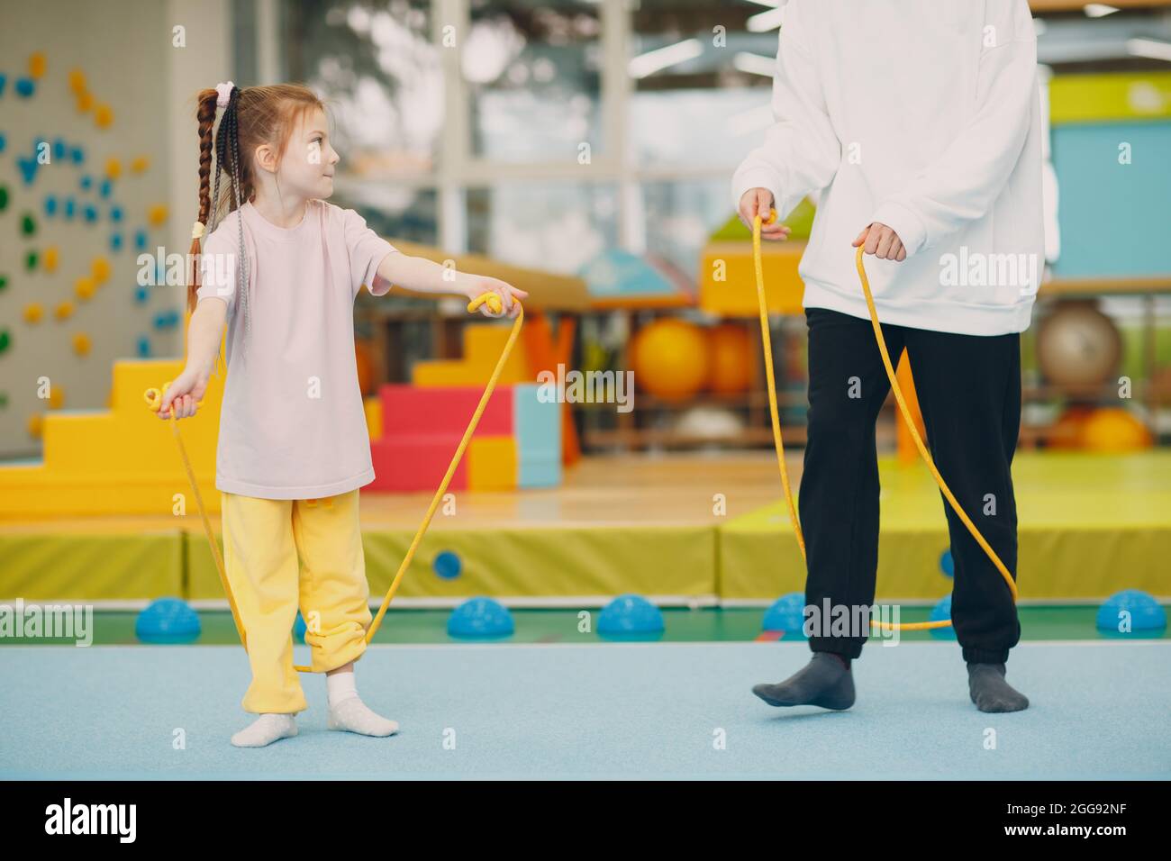 Kids doing exercises with skipping rope in gym at kindergarten or ...