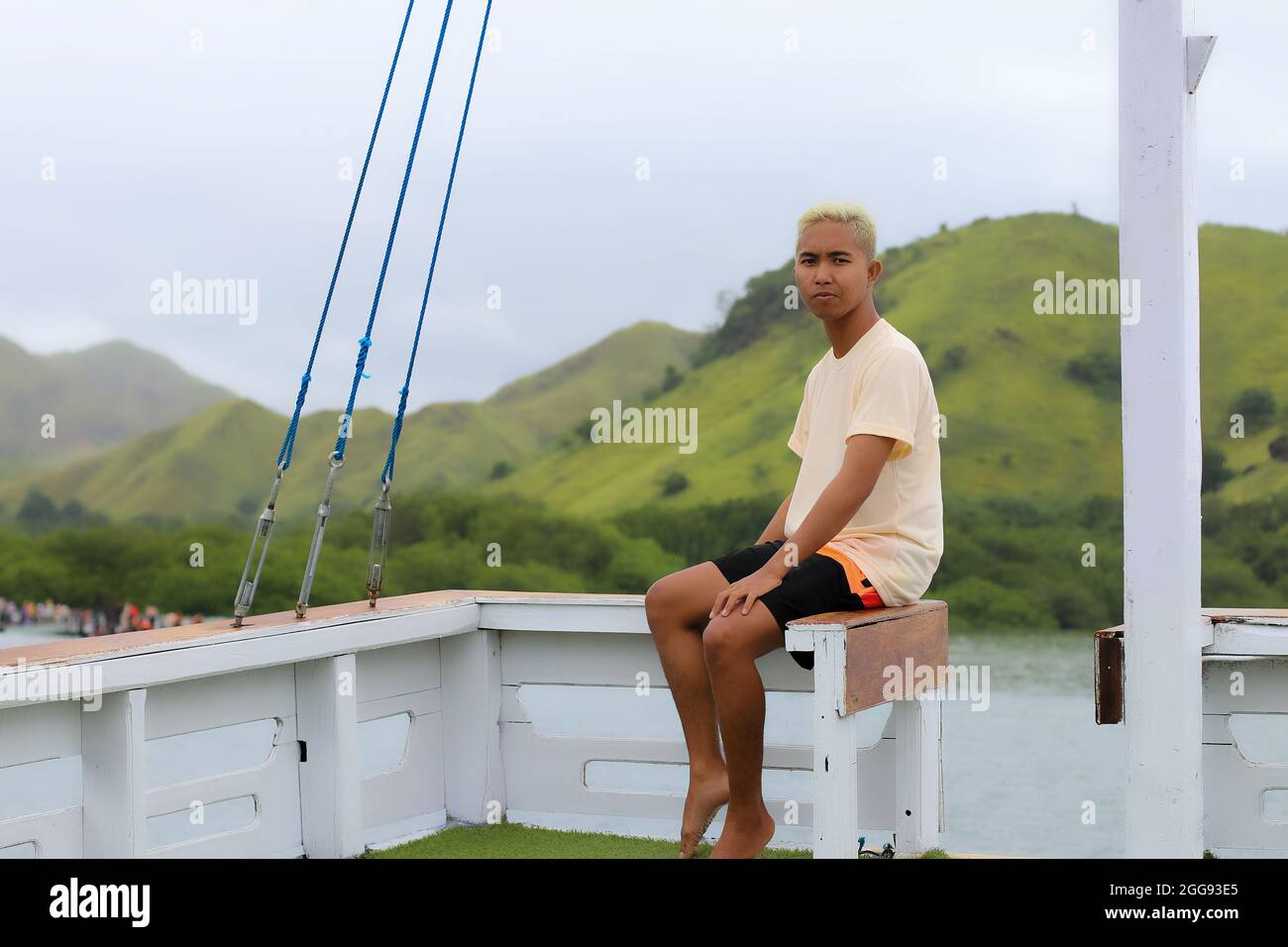 view of a man enjoying on the sailing traditional phinisi in Labuan ...