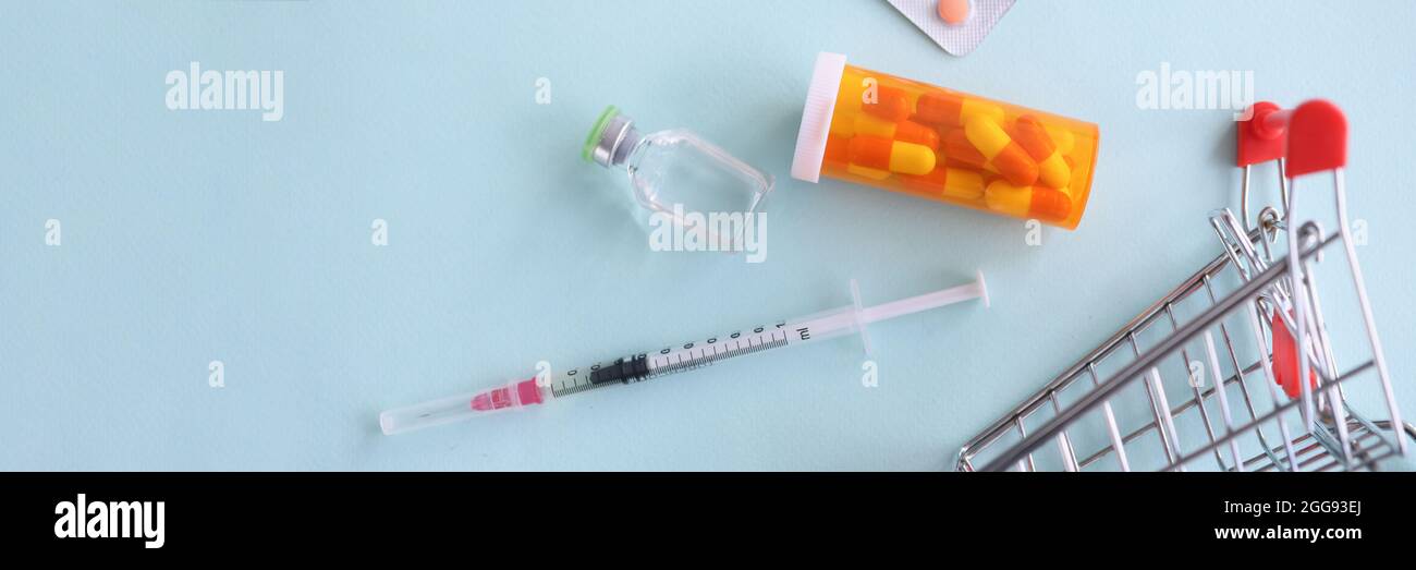 Many medicines and syringe lying near toy metal basket closeup Stock ...