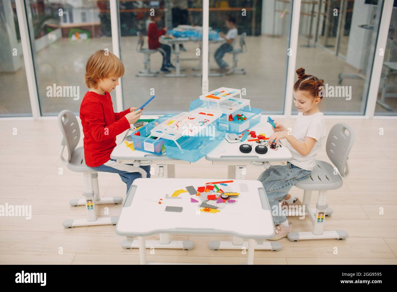 Smiling kids boy and girl child constructor checking technical toy ...