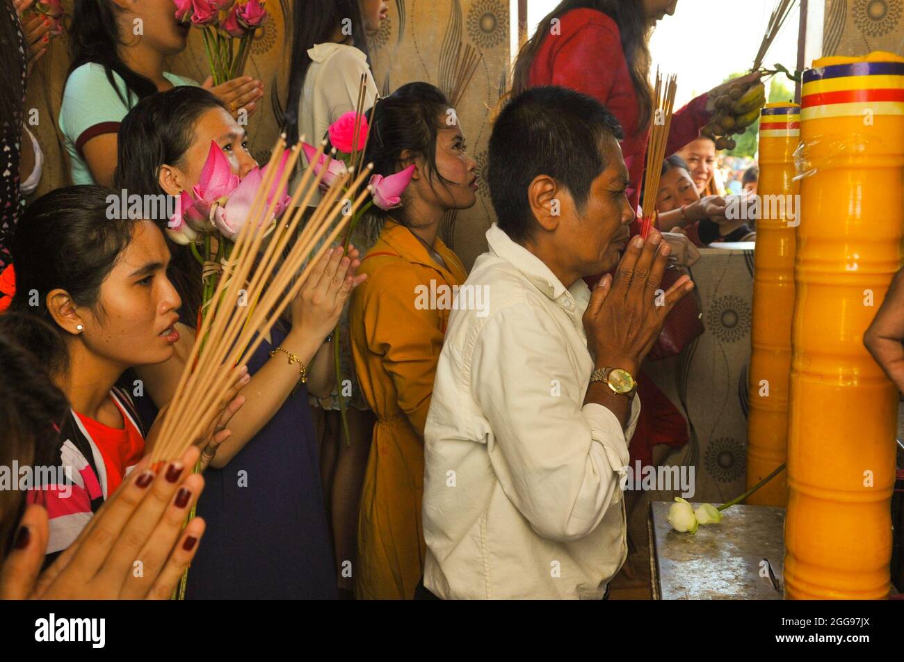 Cambodian women pray w/ incense sticks at a small Buddhist temple on ...