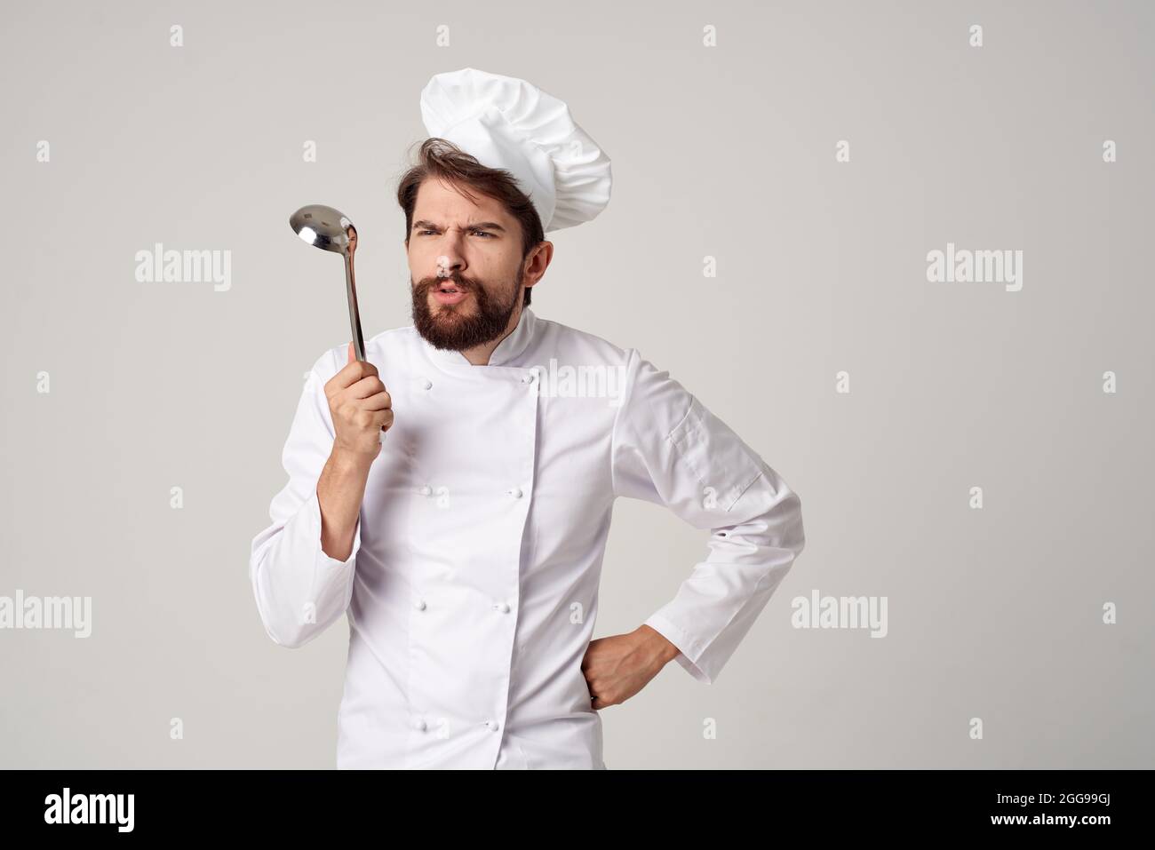 Cheerful chef with a ladle in his hands is trying food Gourmet ...