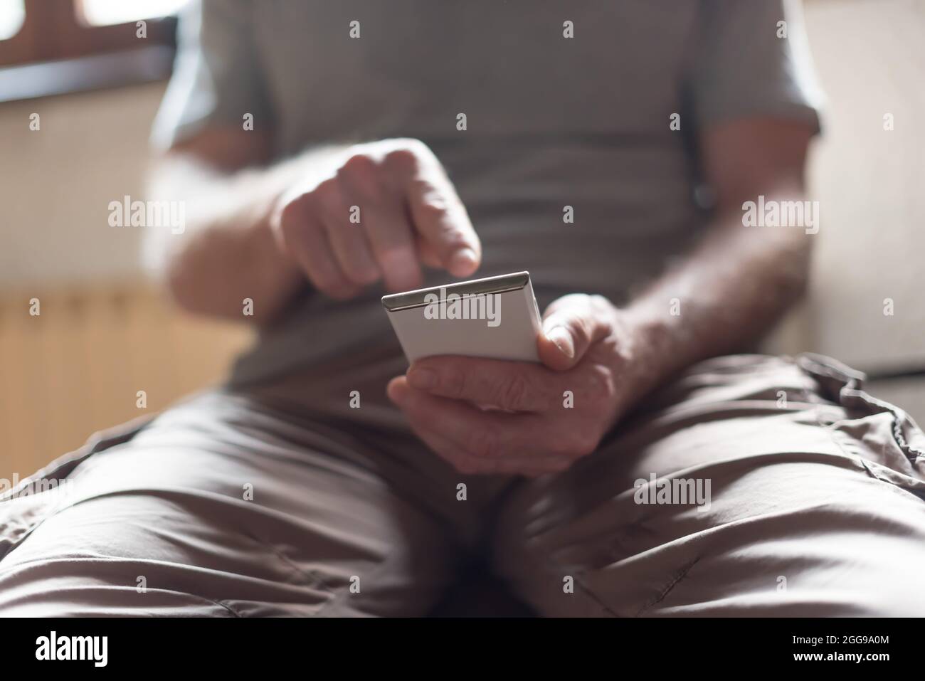 Man sitting using his smartphone Stock Photo - Alamy