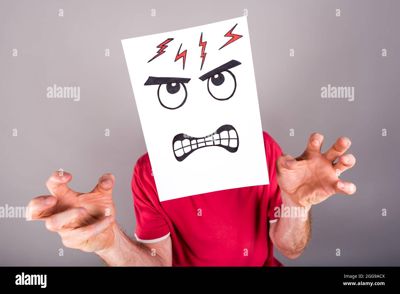 Man behind a paper with a anger expression Stock Photo - Alamy