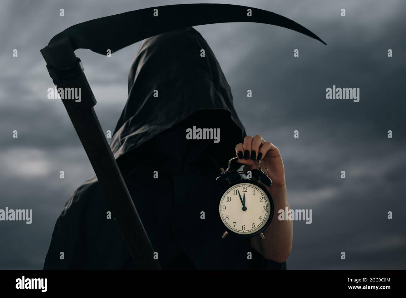Human in a death suit holds a scythe and a watch Stock Photo - Alamy