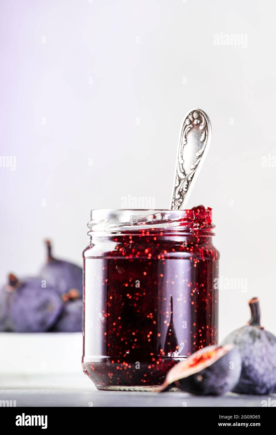 Fig confiture in glass jar. Fresh fruits on gray kitchen table ...