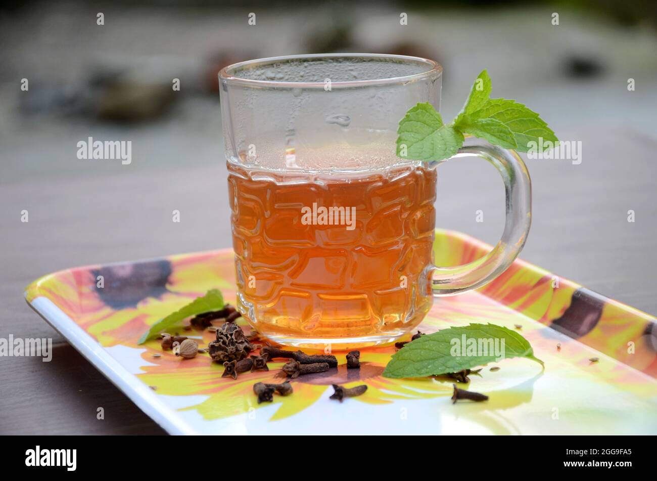Closeup of the tea in the glass cup with black cloves, black pepper ...