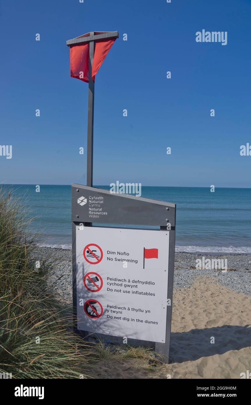Red warning flag for swimming as people enjoying the summer sun on ...