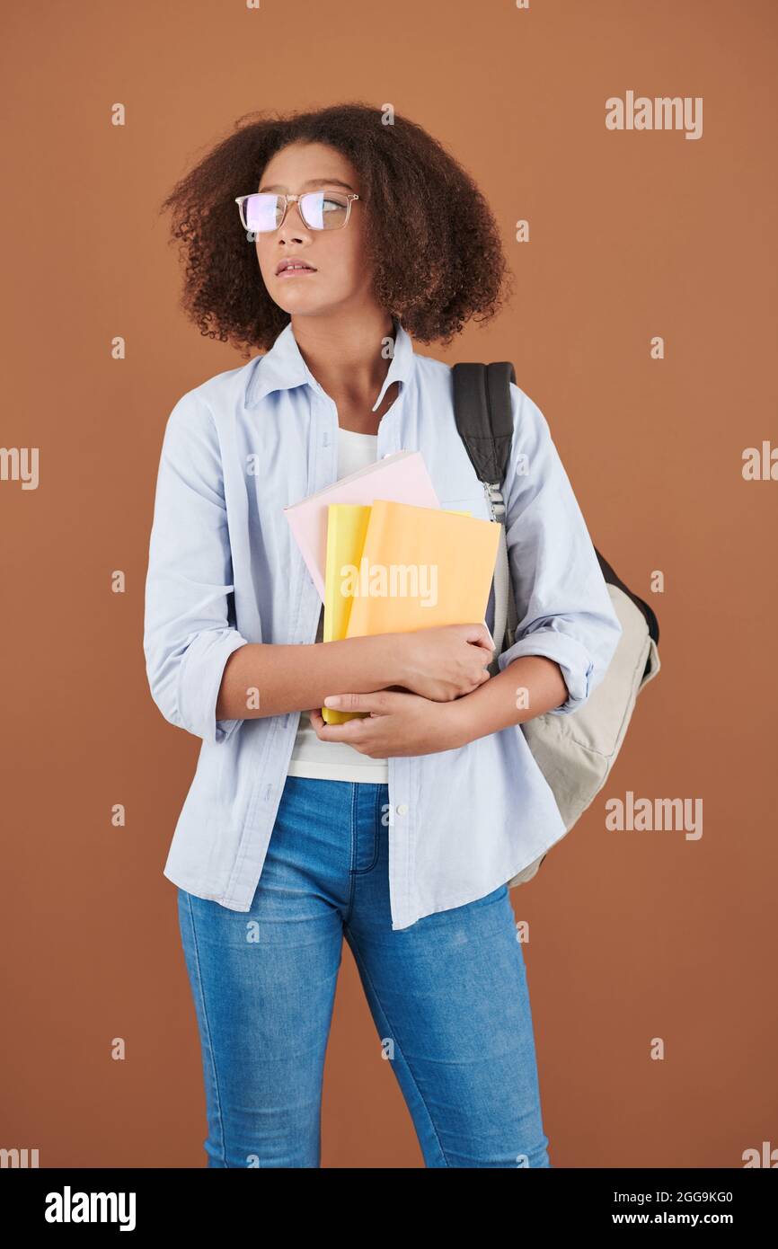Portrait of smart teenage school student with backpack holding many ...