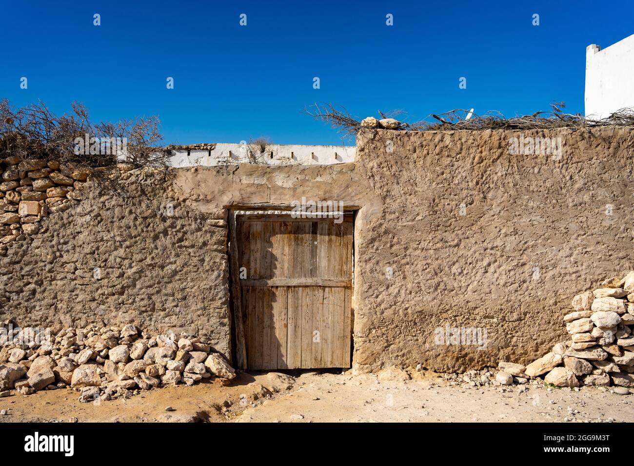 Exterior view of a house with a wooden door in Ghazoua, Morocco Stock ...